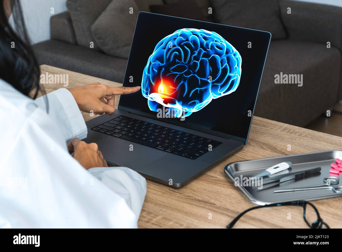 Doctor showing a x-ray of pain in the brain on a laptop. Migraine ...