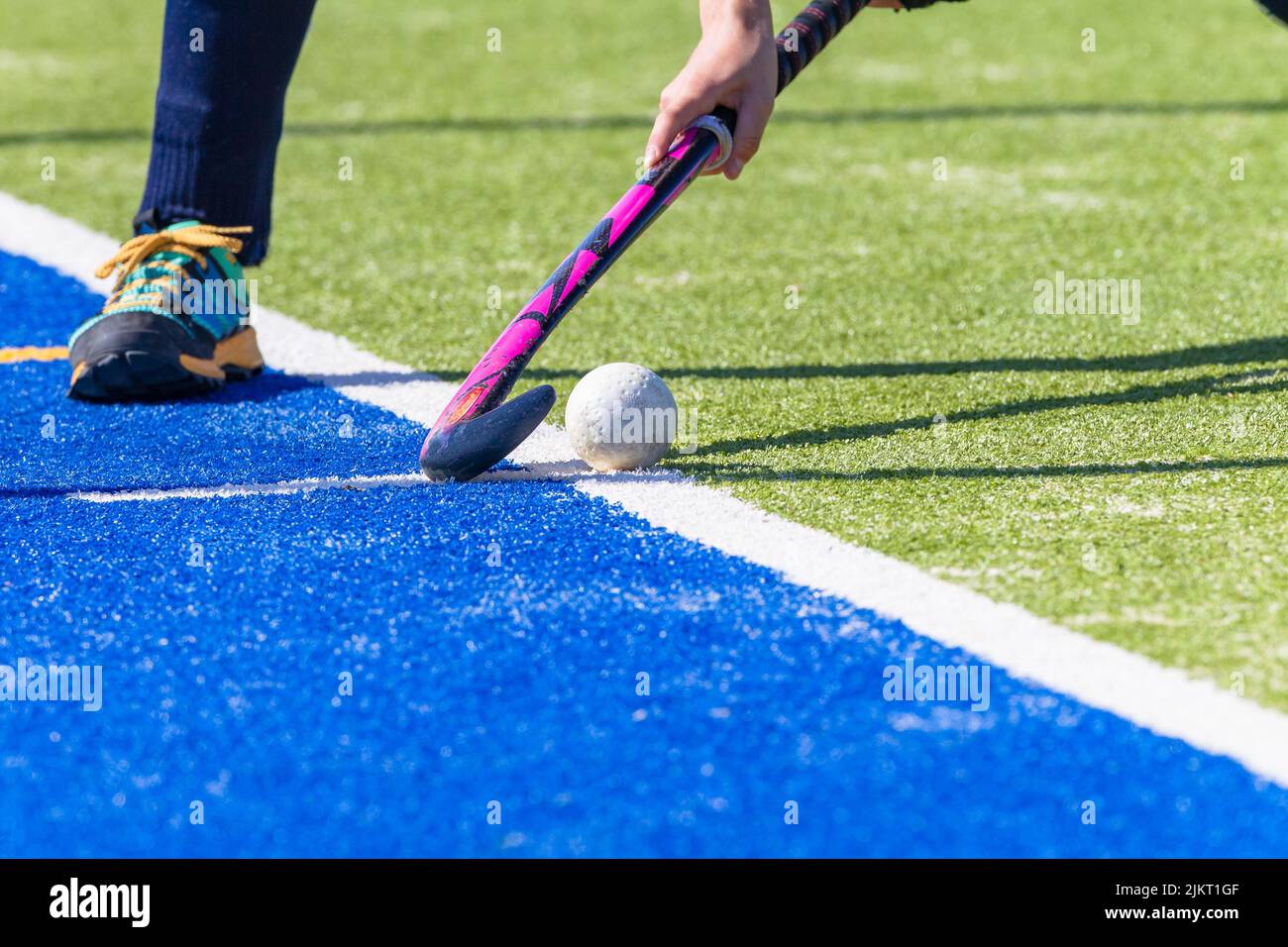 Hockey game player hand leg short corner with ball and stick on astro ...