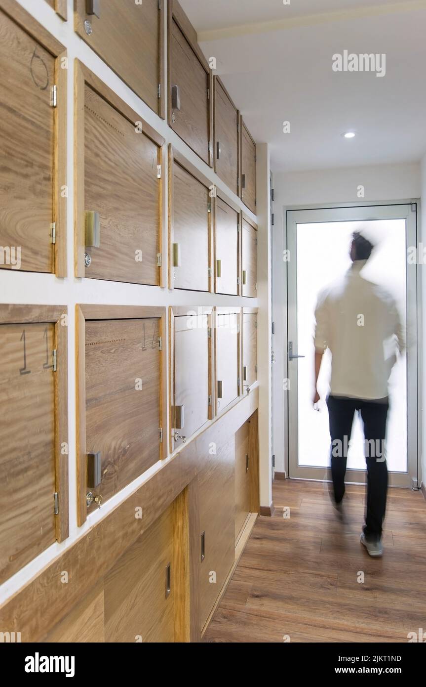 young man, Hispanic boy, walking with sweeping effect, in the lockers ...