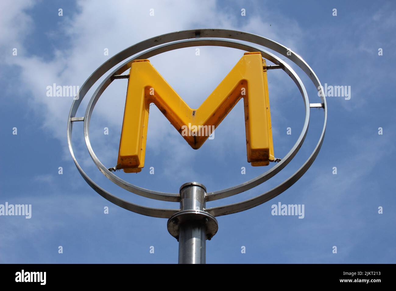 Modern version of the Paris Metro sign - a single bright yellow capital ...