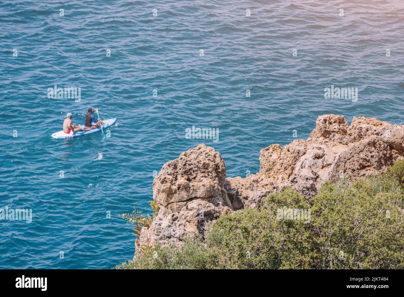 Two people rowing on kayak or sap board swim and travel along the ...