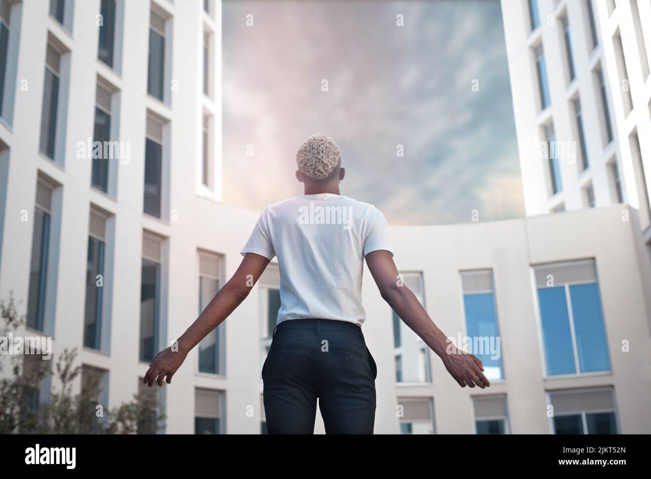 Back view of anonymous male with dyed hair in casual clothes standing ...