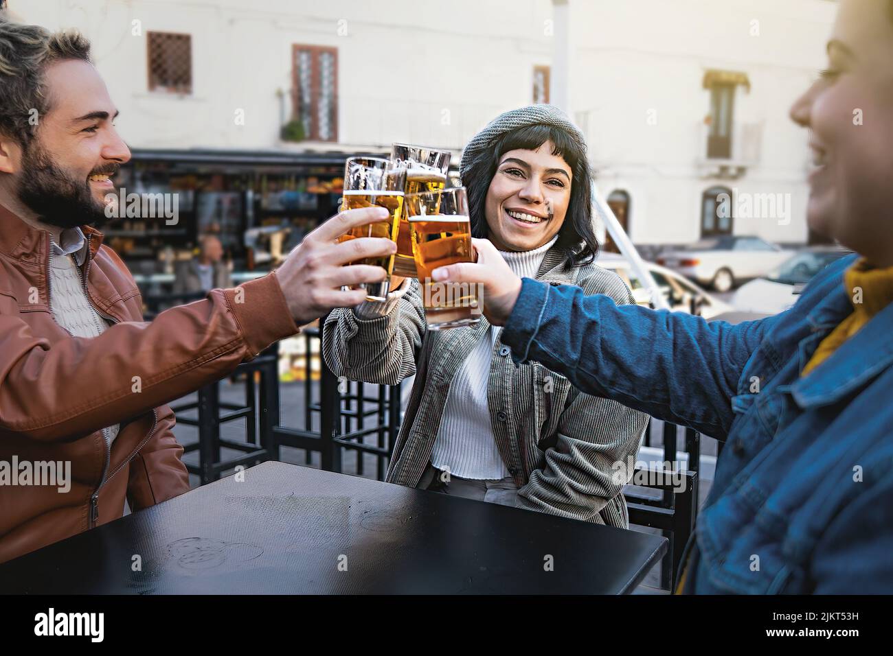 Group of young people celebrating friendship toasting with beers ...