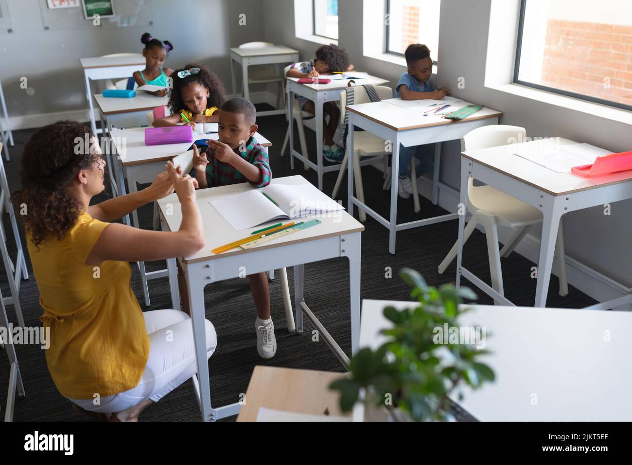 Young caucasian female teacher teaching sign language to african ...