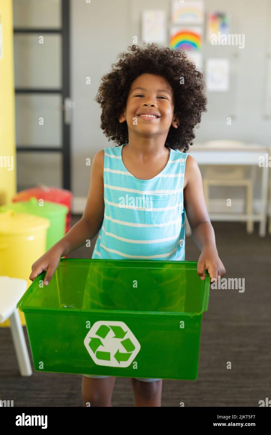 Portrait of smiling african american elementary schoolboy holding ...