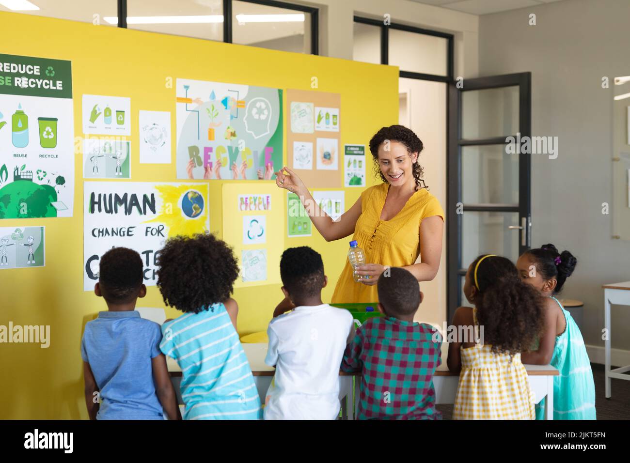 Caucasian female teacher teaching environmental conservation to african ...