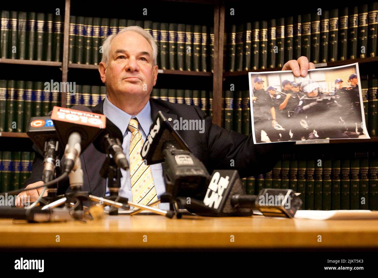 Lawyer Clayton Ruby, holding a picture of a police officer aiming a ...