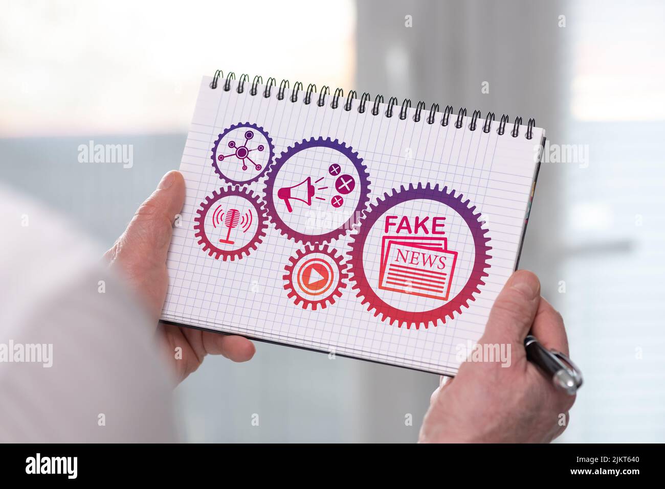 Hand holding a notepad with fake news concept Stock Photo - Alamy