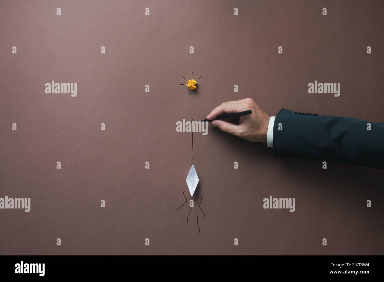 Businessman drawing an arrow towards a lightbulb for an origami made ...