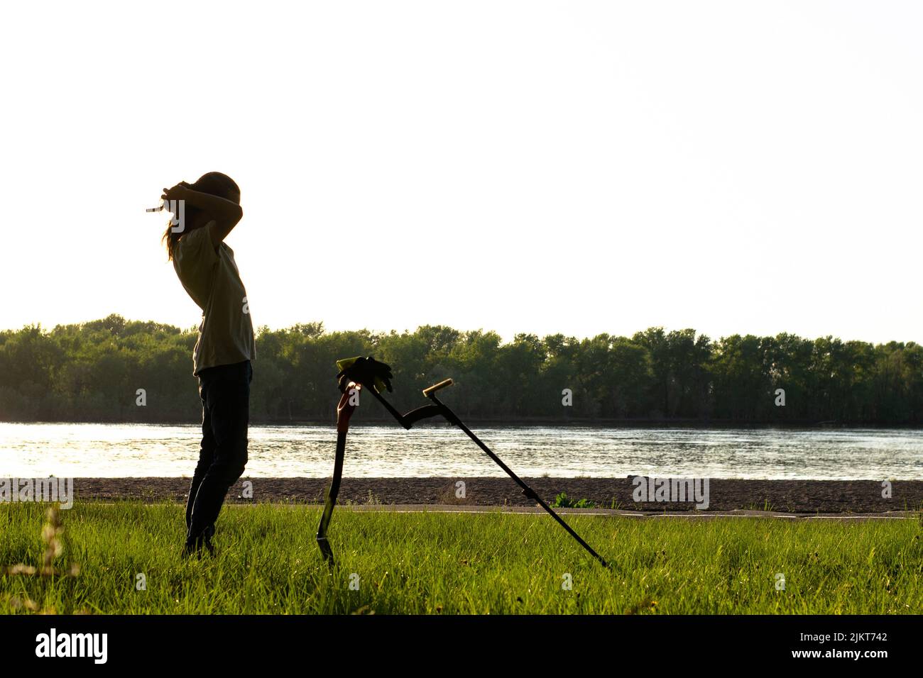 Silhouette of a guy who puts on wireless headphones. In front of him ...