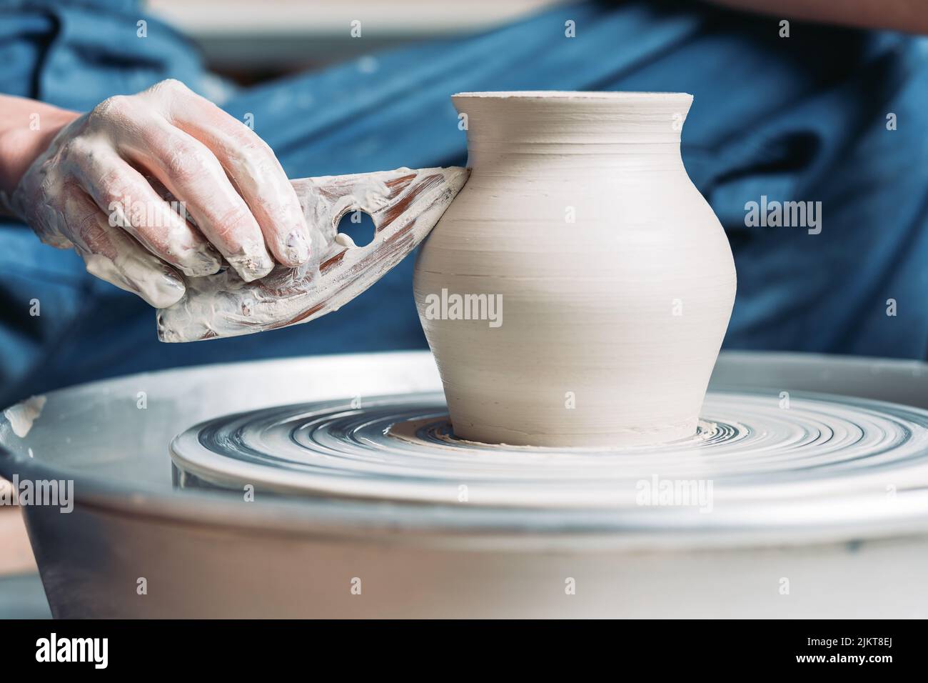 Woman hands working with tool on pottery wheel and making a pot Stock ...