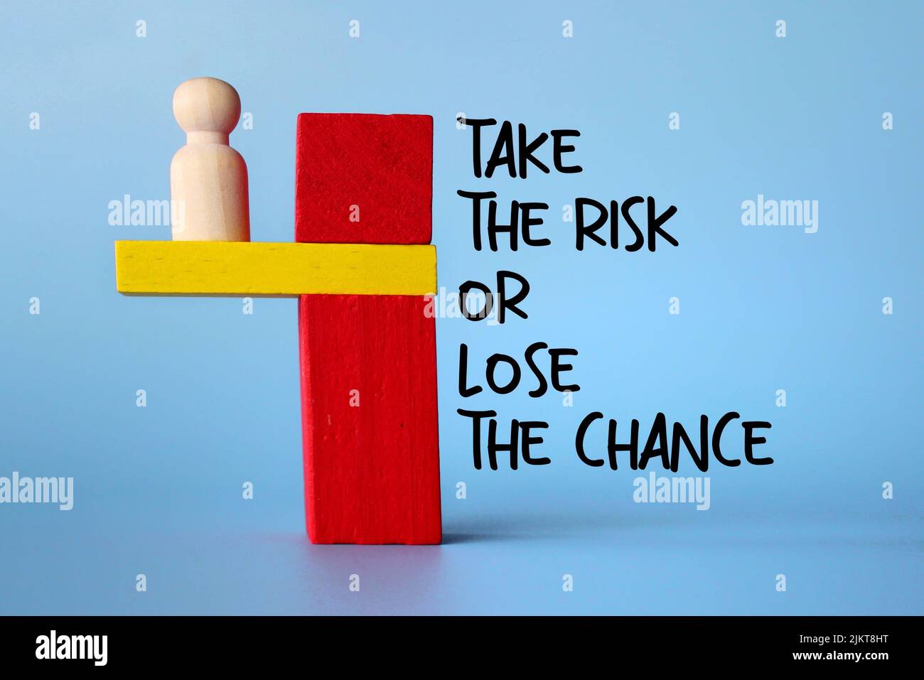 Quotes " Take the risk or lose the chance" with wooden doll on blue ...