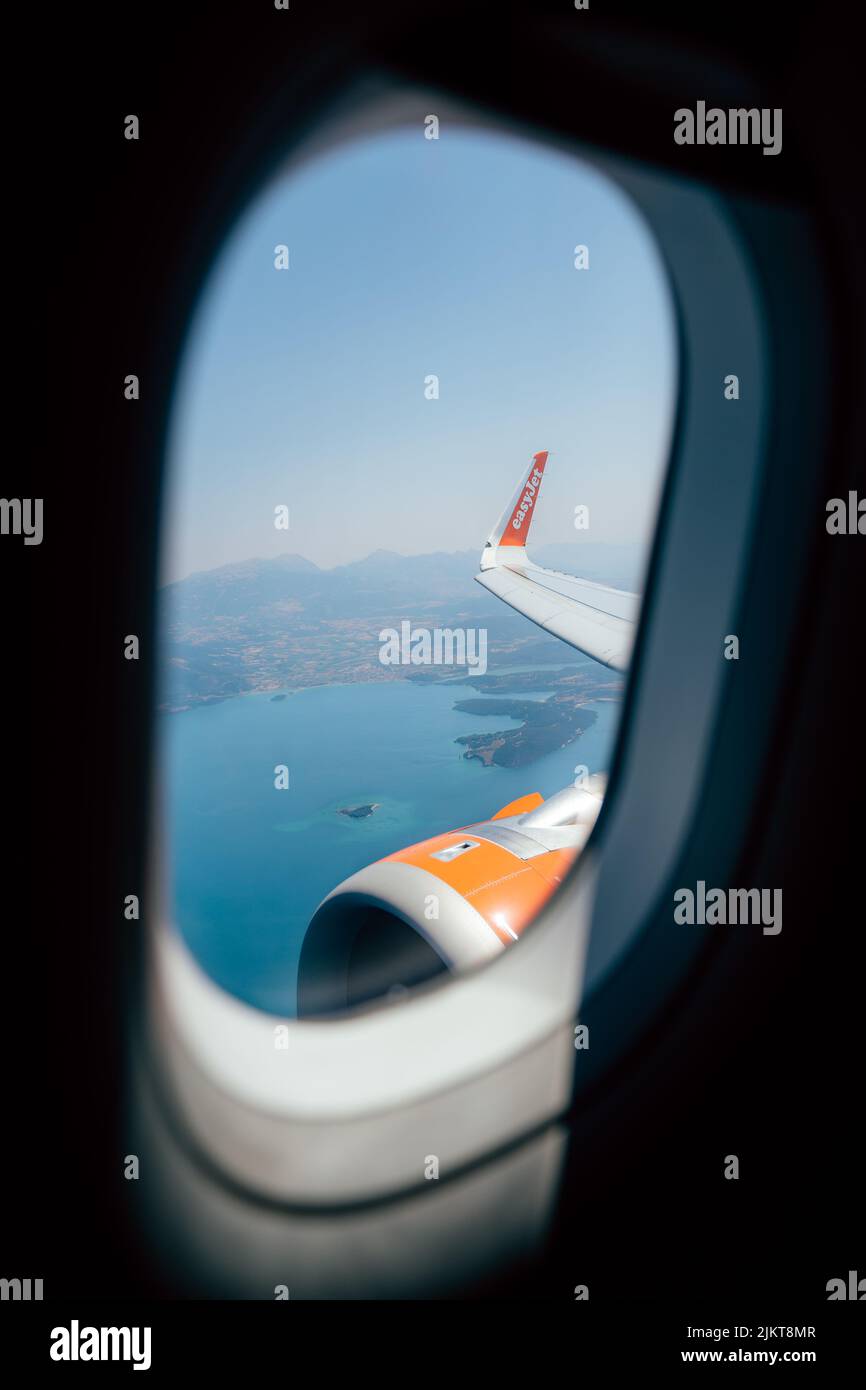 A vertical shot of the plane window looking down onto the Greek island ...