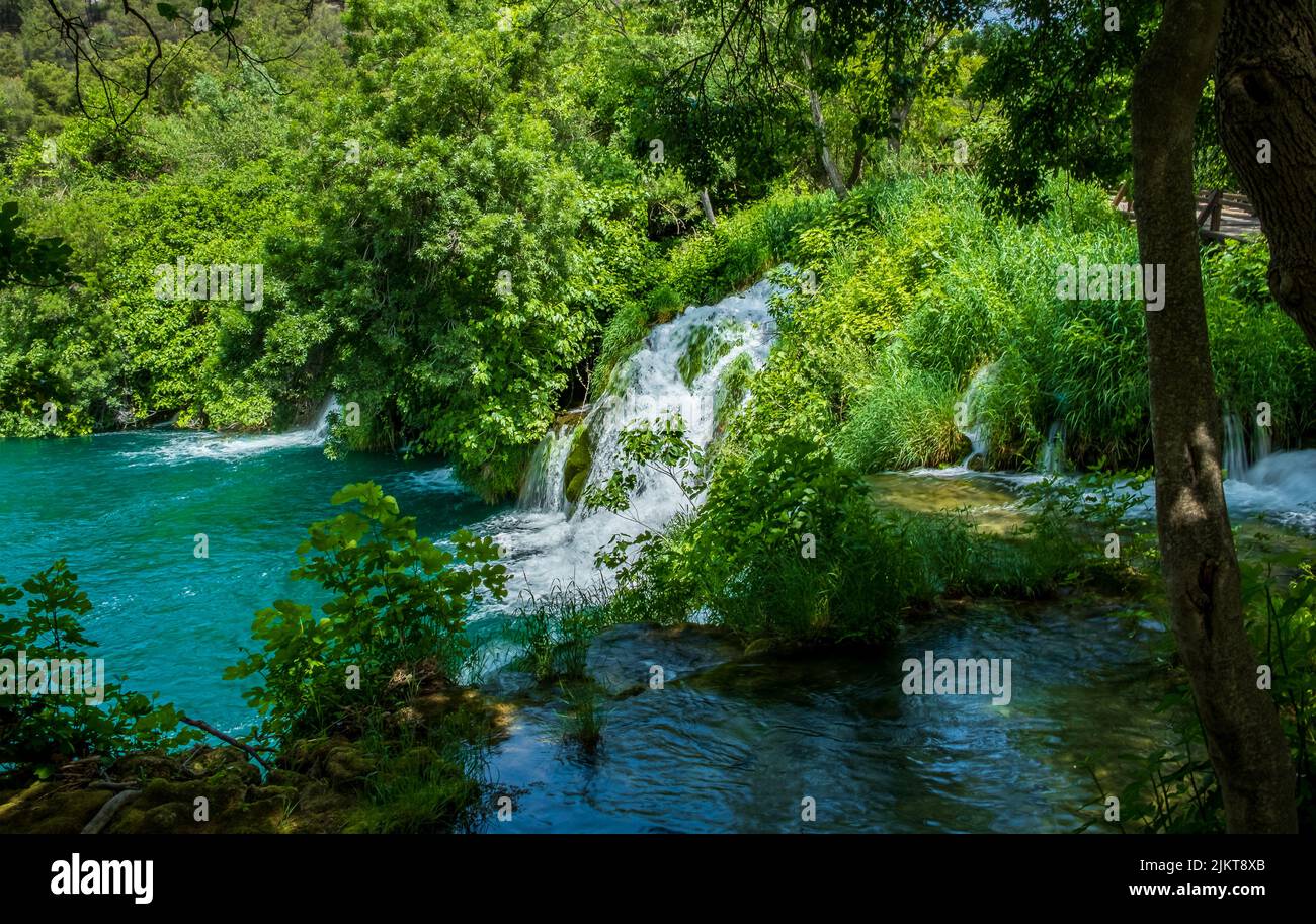 Cascading waterfall forms a pool of aqua colored water at Krka National ...