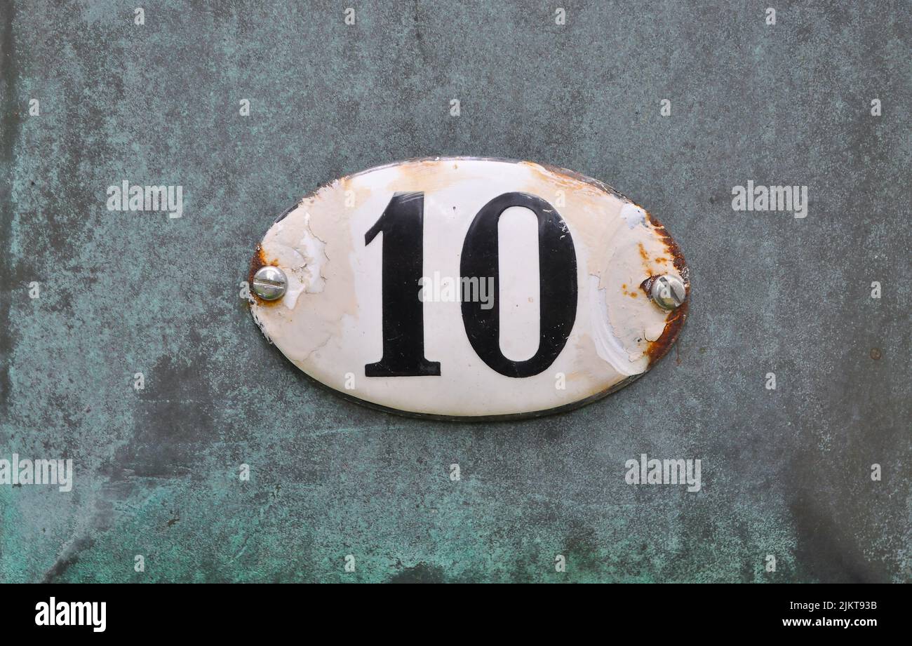 The number 10 on a white metal over a background of a grey wall Stock ...