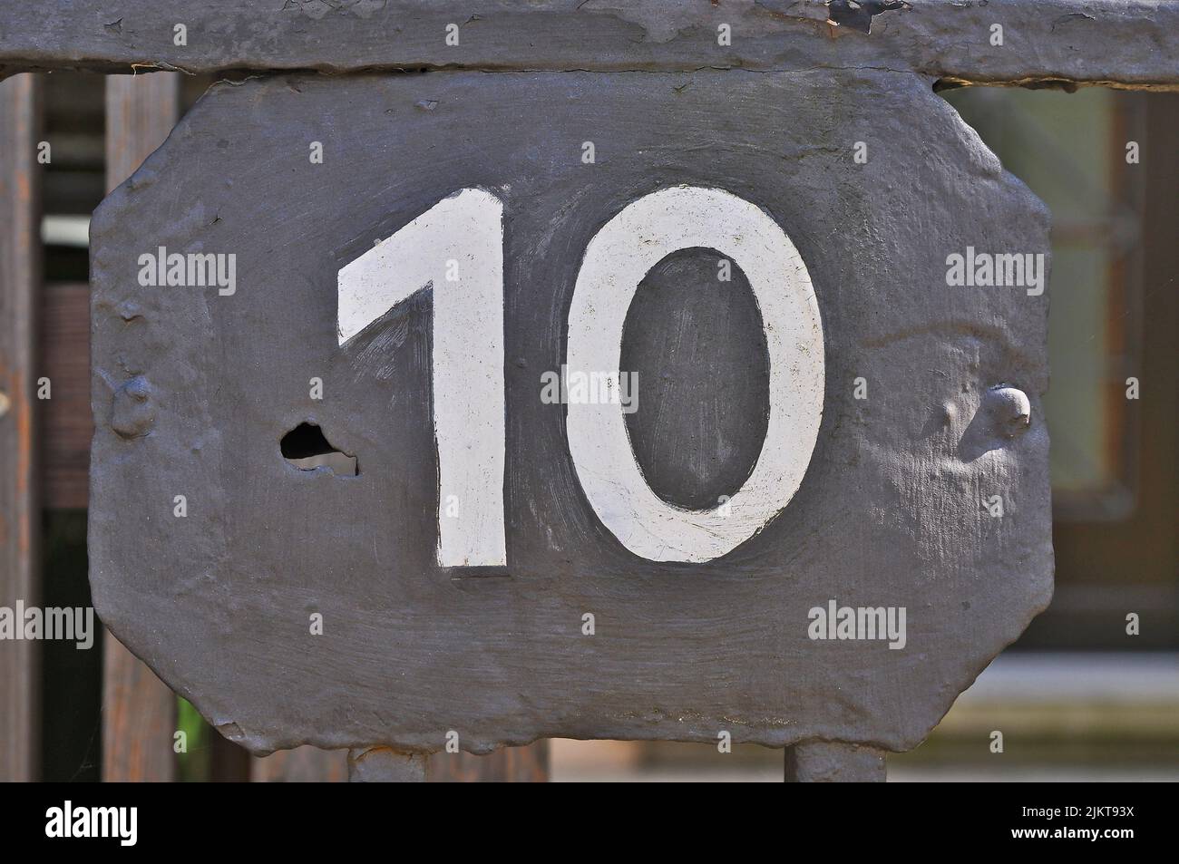The number 10 in white color painted on a metal material hanged outside ...