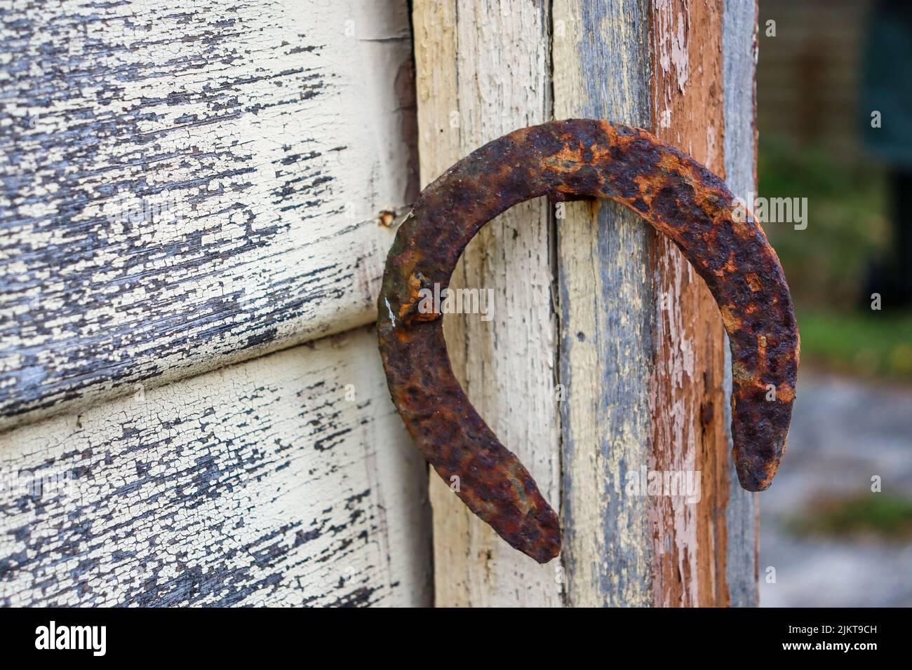 old rusty horse shoe hanging on nail on old weatherboard wall Stock ...