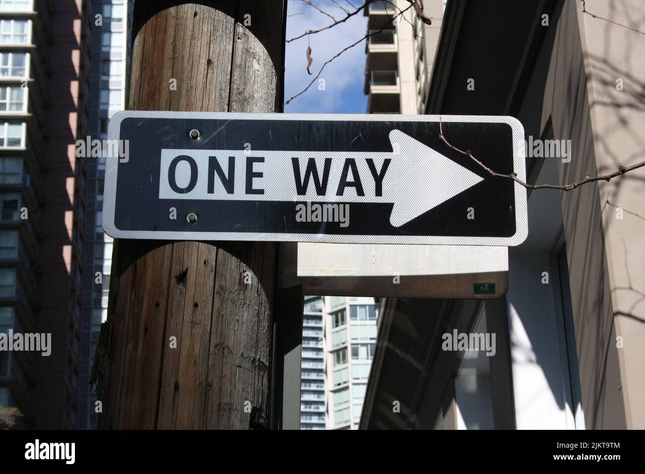 A direction sign with an arrow and text one way in downtown Vancouver ...
