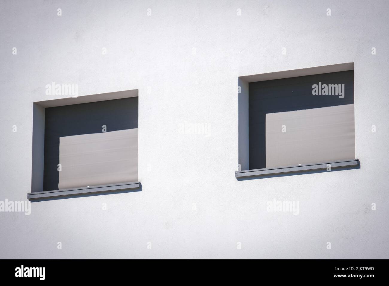 A front view of roller blinds on the windows of a building in daylight ...