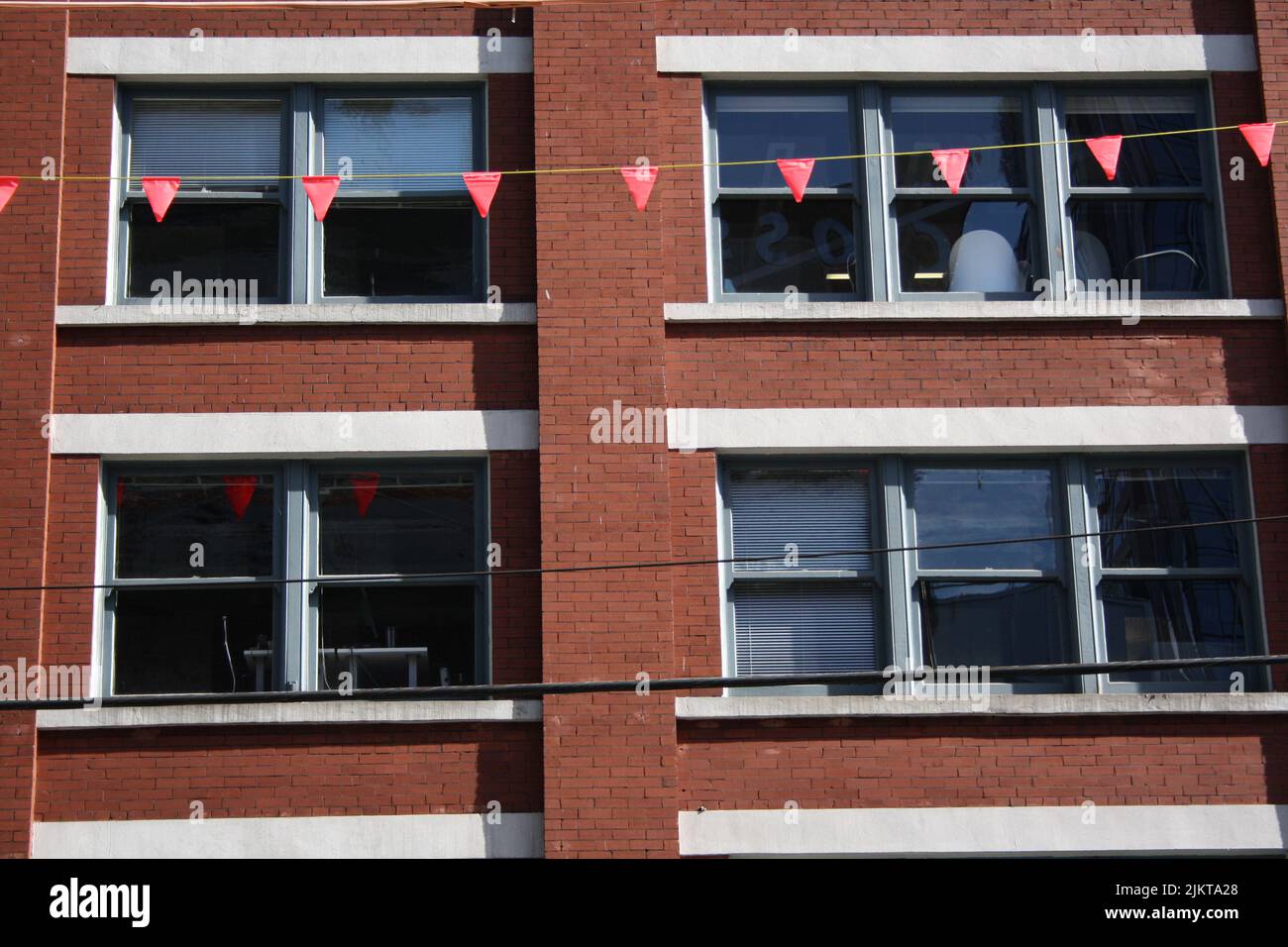 The flags hanging on the brick building with windows Stock Photo - Alamy