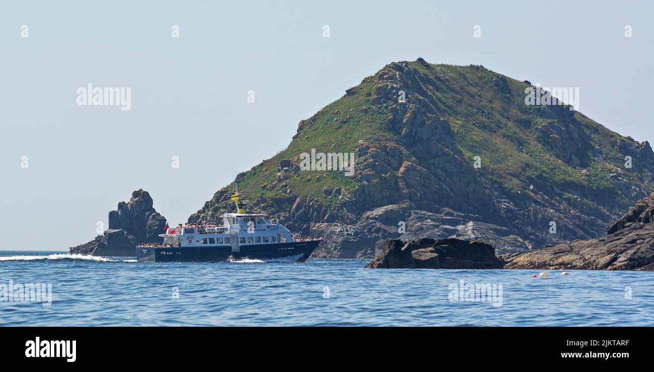 A passenger ferry floating in the sea near high rocky mountain Stock ...