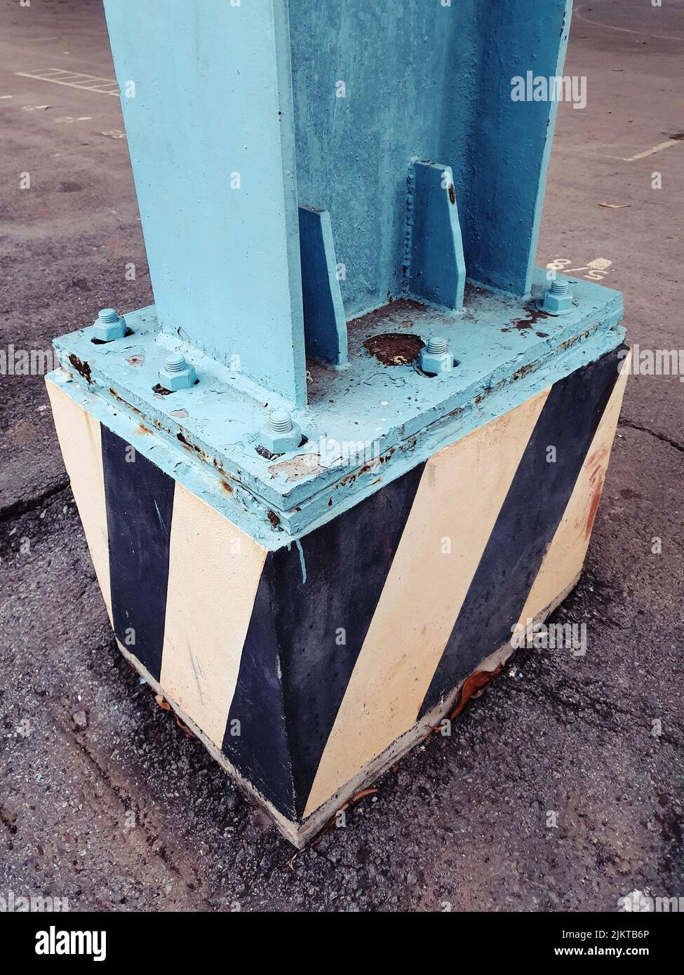 A closeup shot of blue metal pillar fastened to cement block with ...