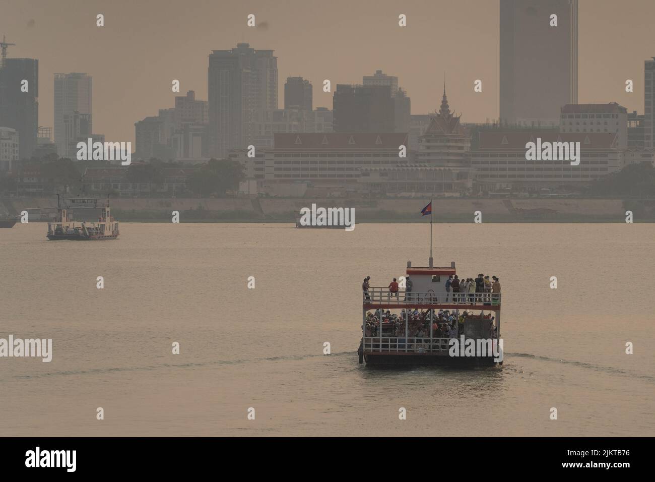 A Ferry on tonle sap mekong junction in front of Kandal at dusty sunset ...