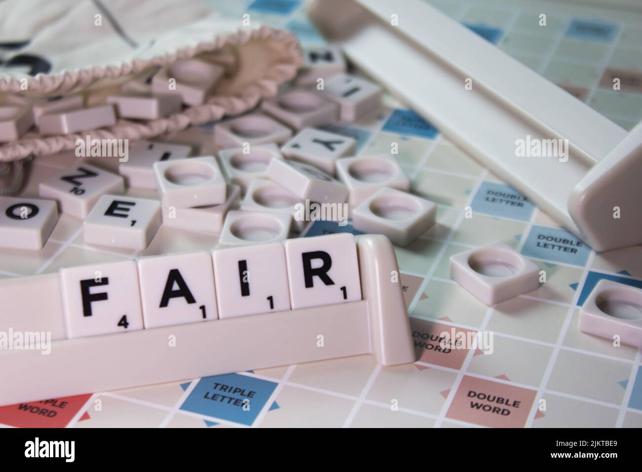 A closeup of the word fair spelling on a white scrambling board game ...