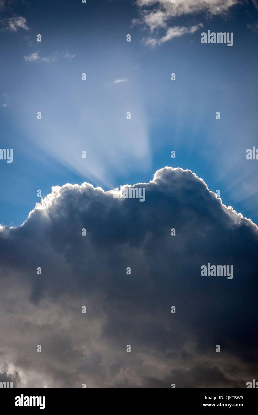 Sun beams behind clouds Stock Photo - Alamy