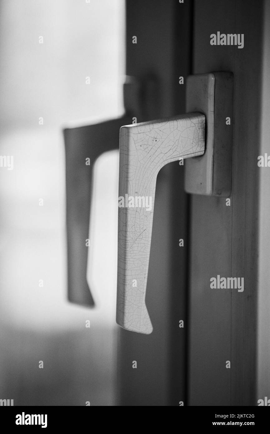 A vertical grayscale closeup of a window handle Stock Photo - Alamy