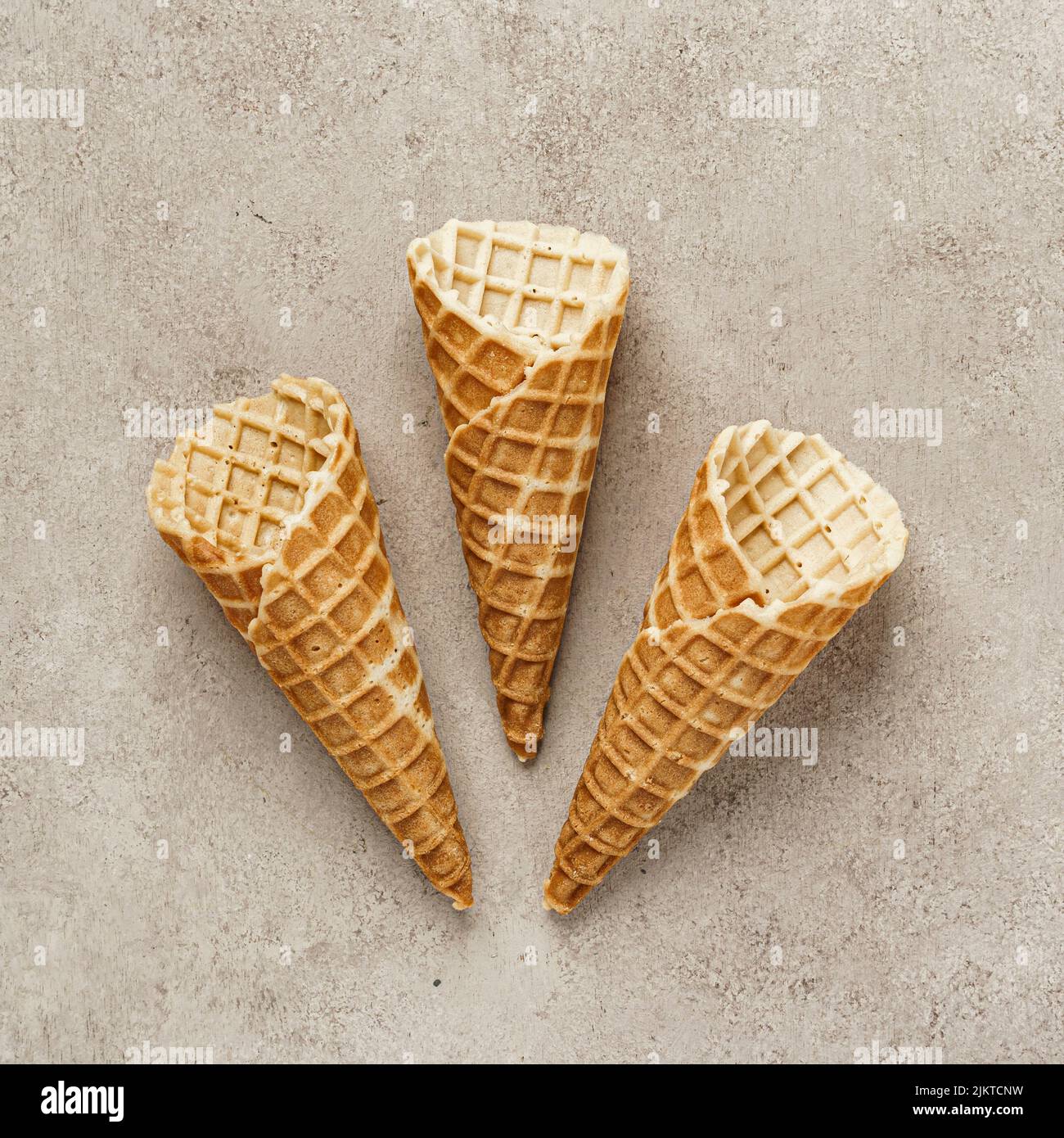 A close-up shot of three empty ice cream cones over brown background ...