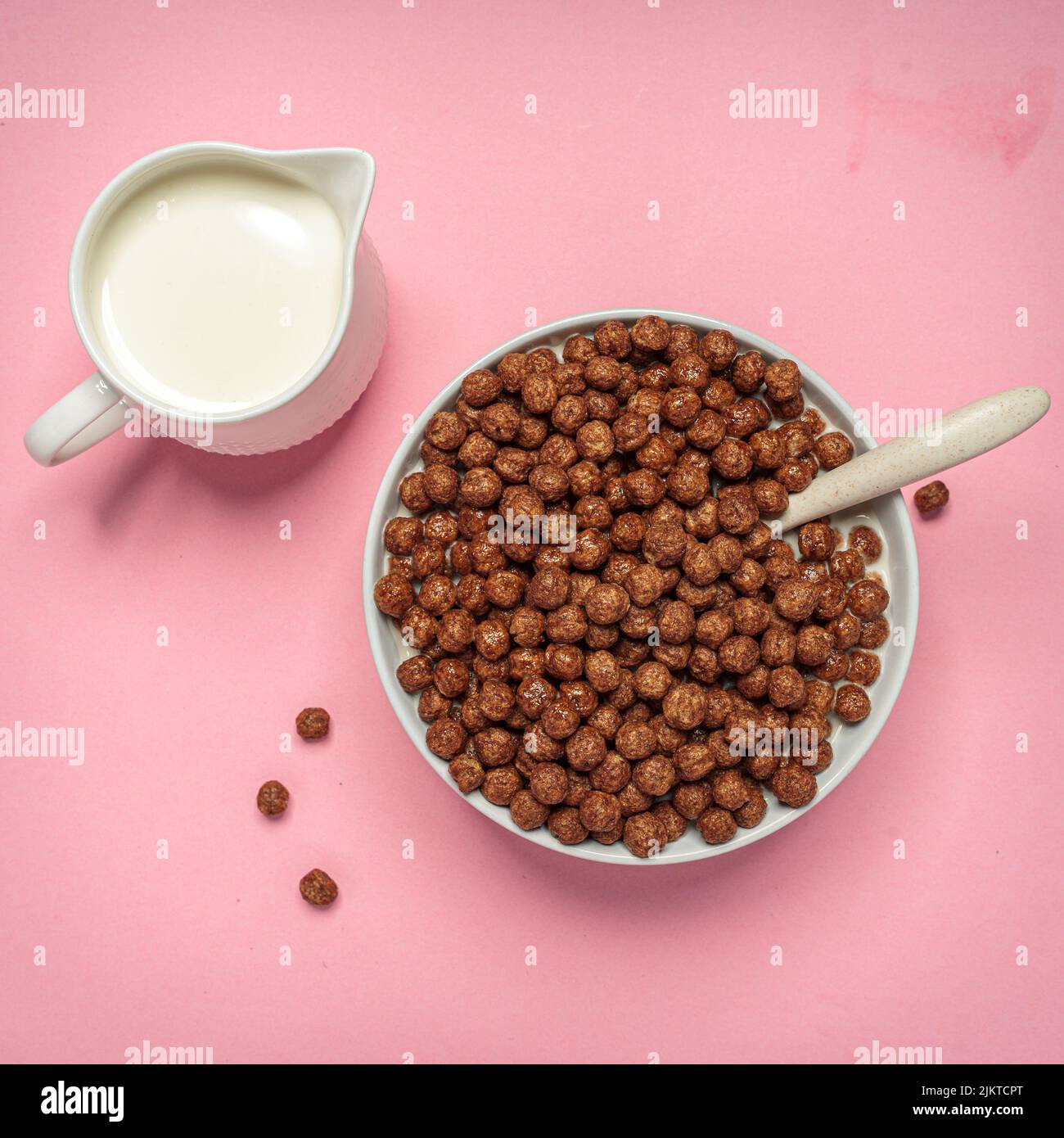 A top view of delicious chocolate cereal with milk isolated on a pink ...