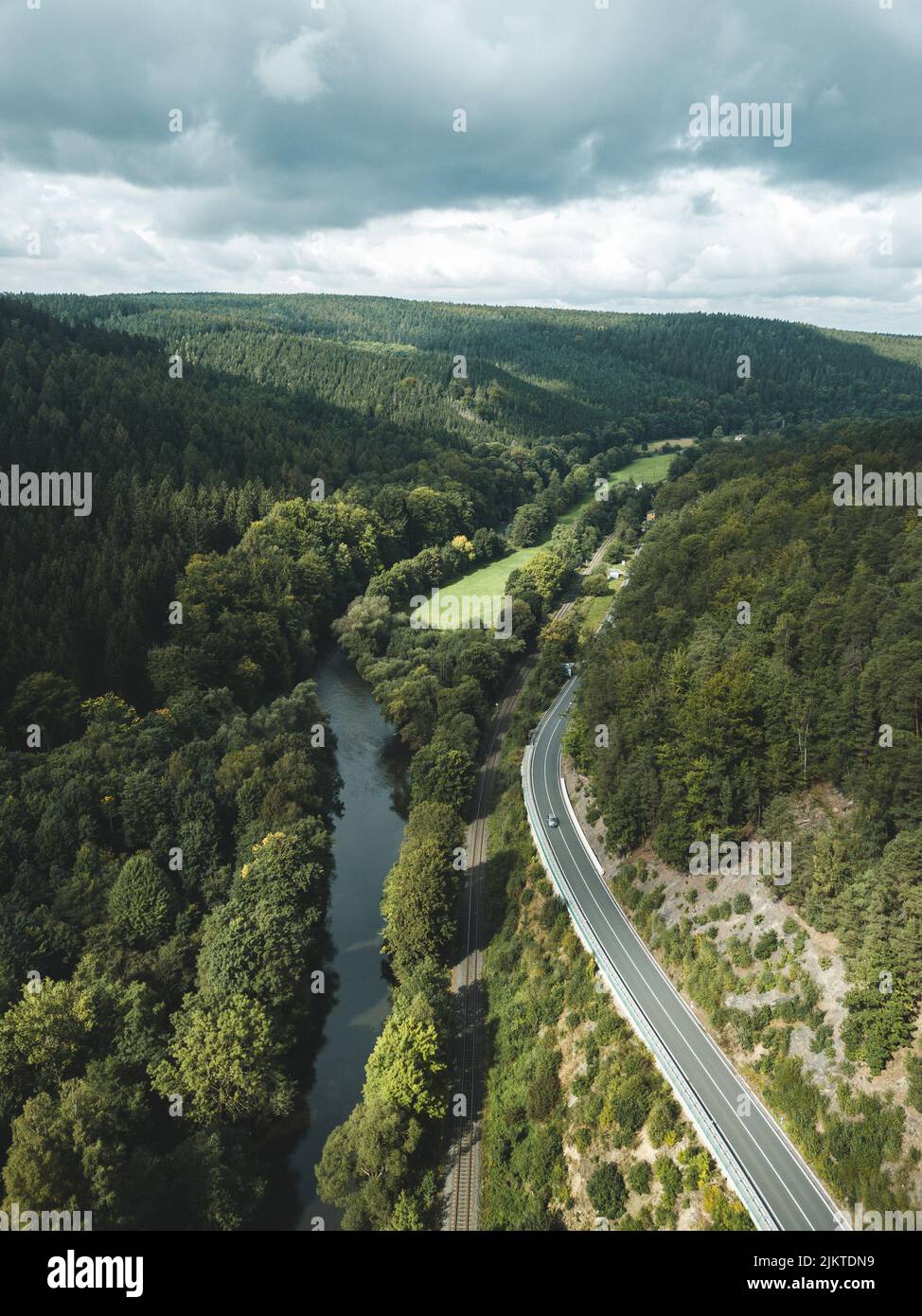 An aerial view of a highway through lush mountain forests in Saxony ...