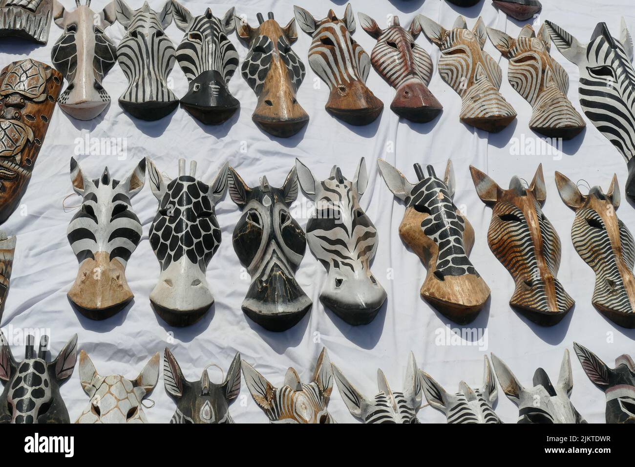 A closeup of giraffe and zebra head wood carvings displayed at a ...