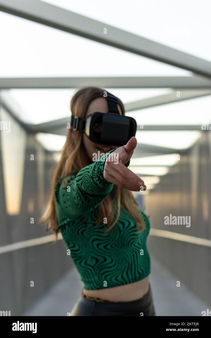Young hispanic woman wearing in virtual reality goggles, touch ...