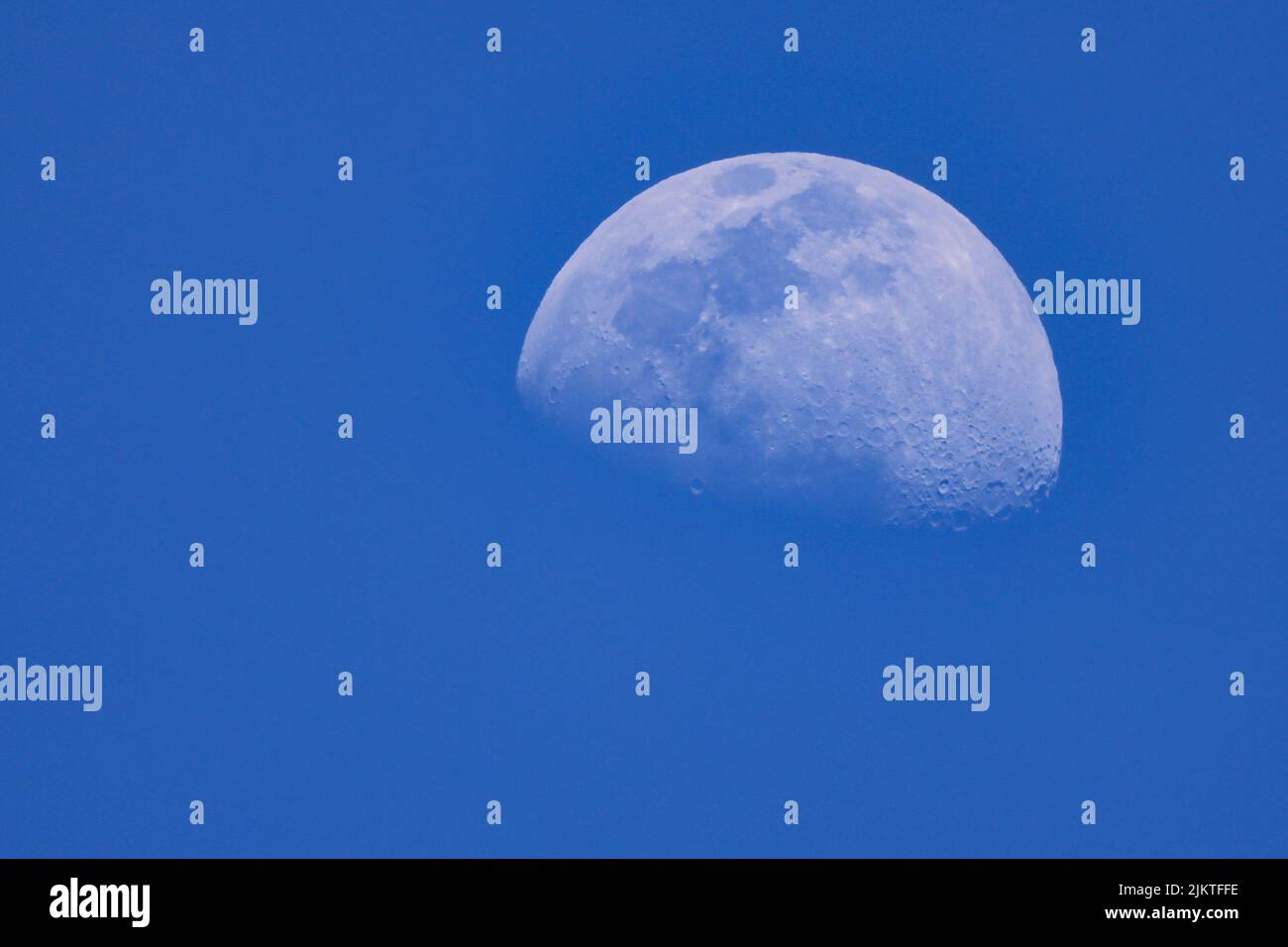 The moon fading in a blue sky Stock Photo - Alamy