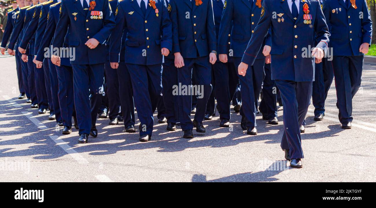 Group of young people dressed in blue military uniforms are marching ...