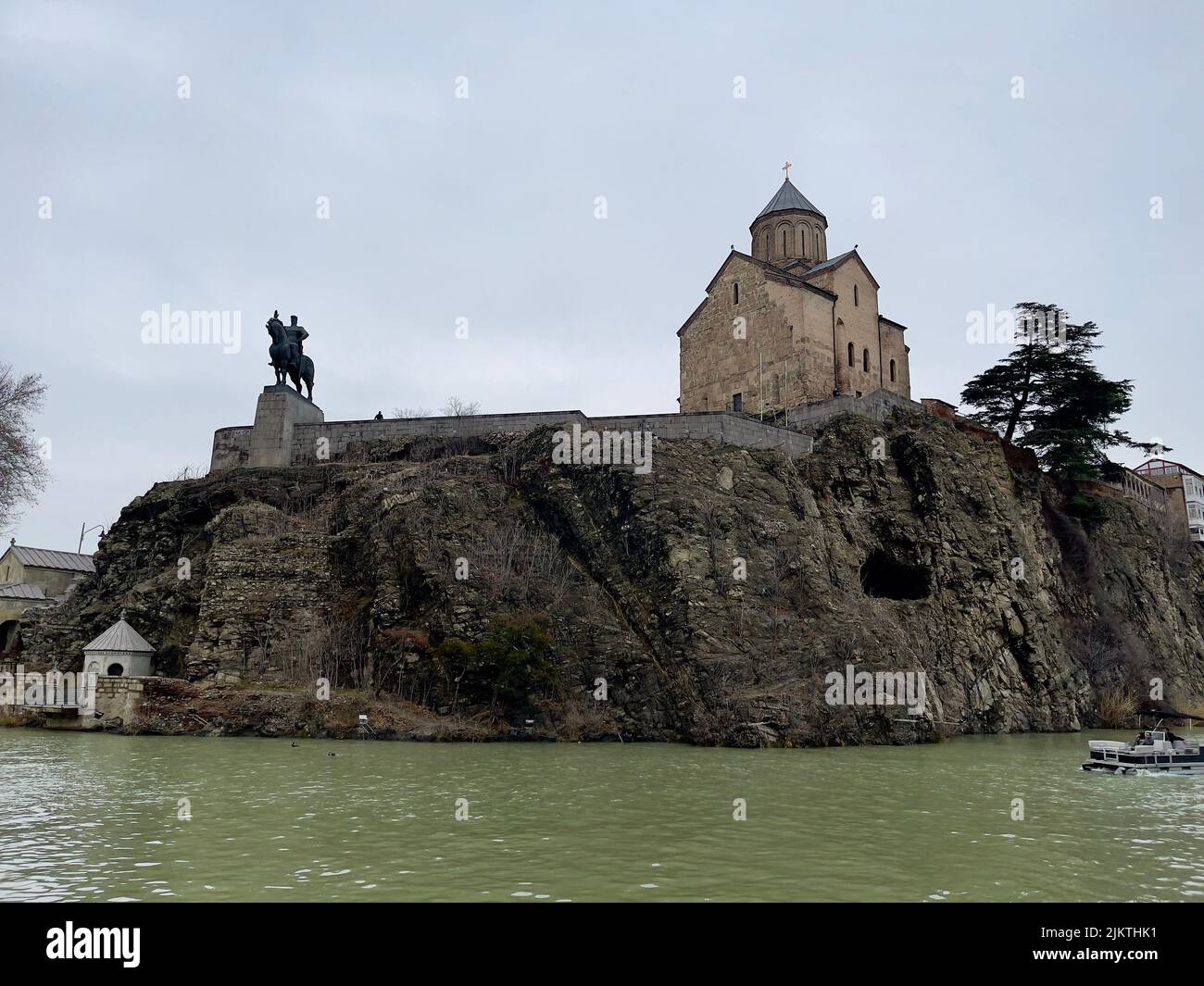 A low angle shot of the Metekhi St. Virgin Church and Mtkvari River in ...