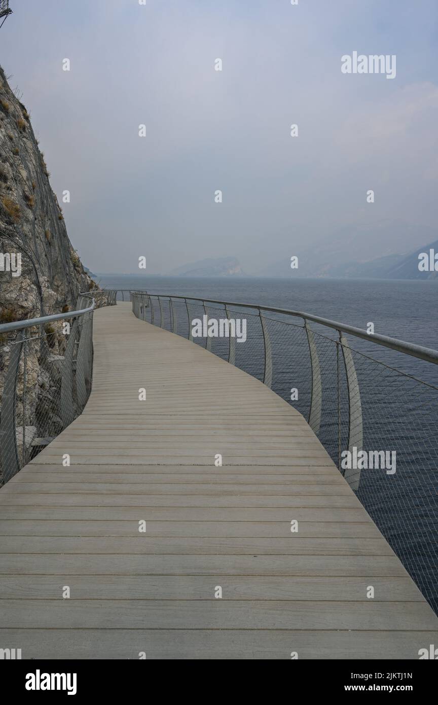 A vertical shot of a walking path hanging on the cliff by the sea Stock ...