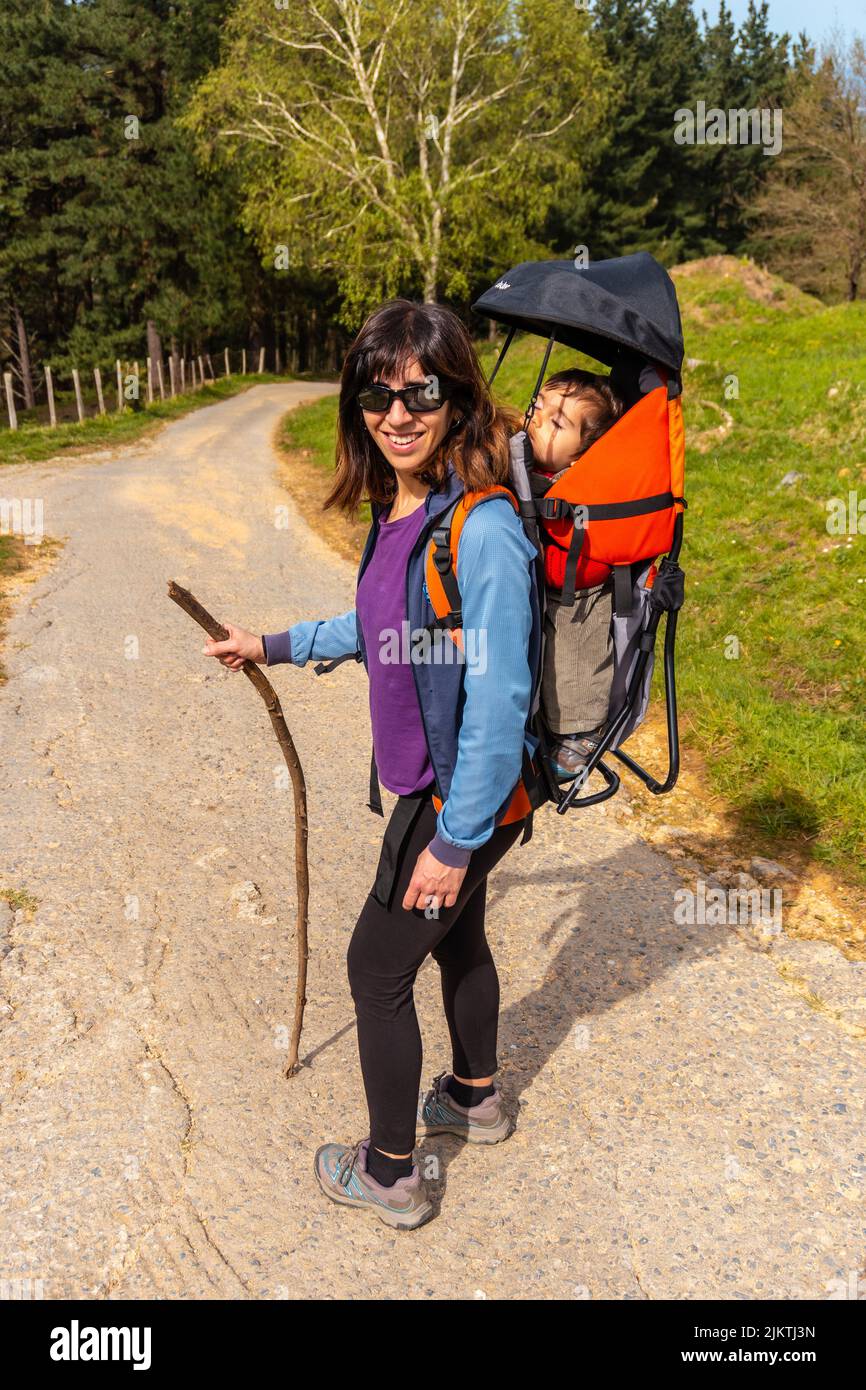 A mother transporting the baby in the trekking backpack, a very ...