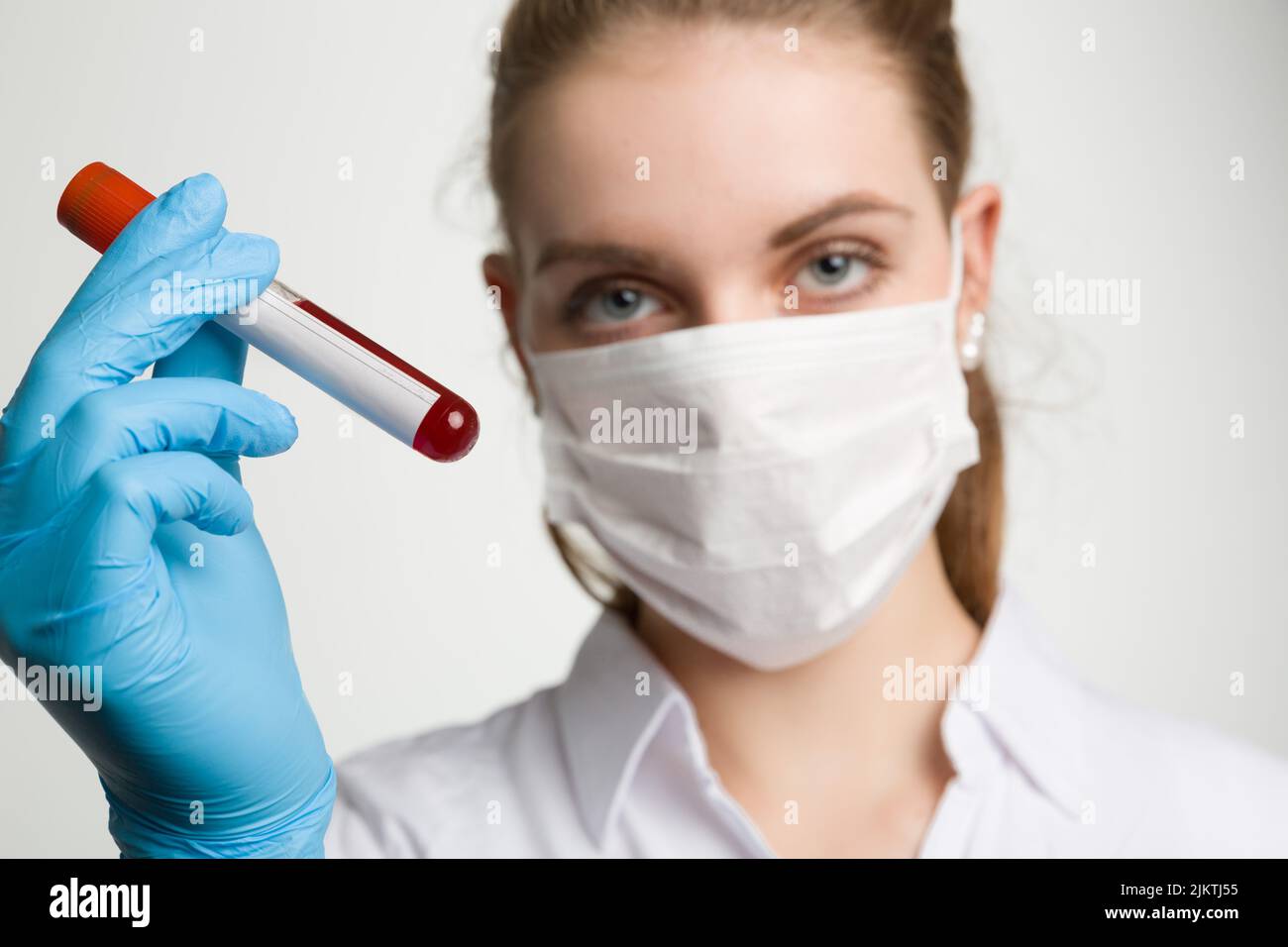 young nurse with medical face mask and medical gloves is presenting ...