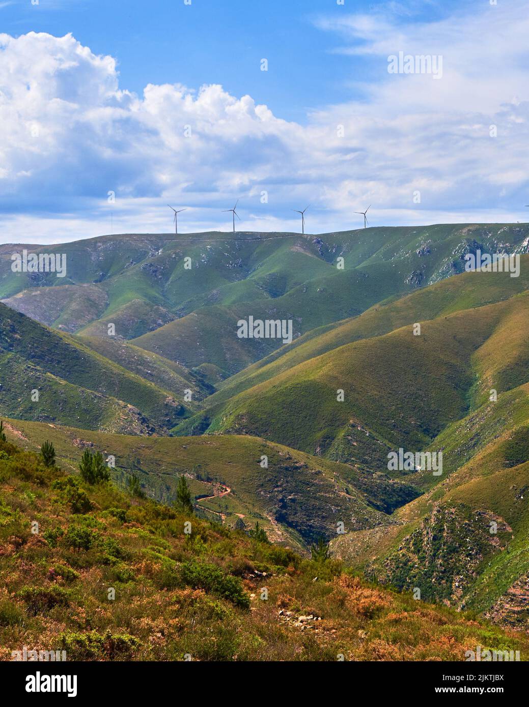 A scenic shot of high hills and mountains with green grass meadows in ...