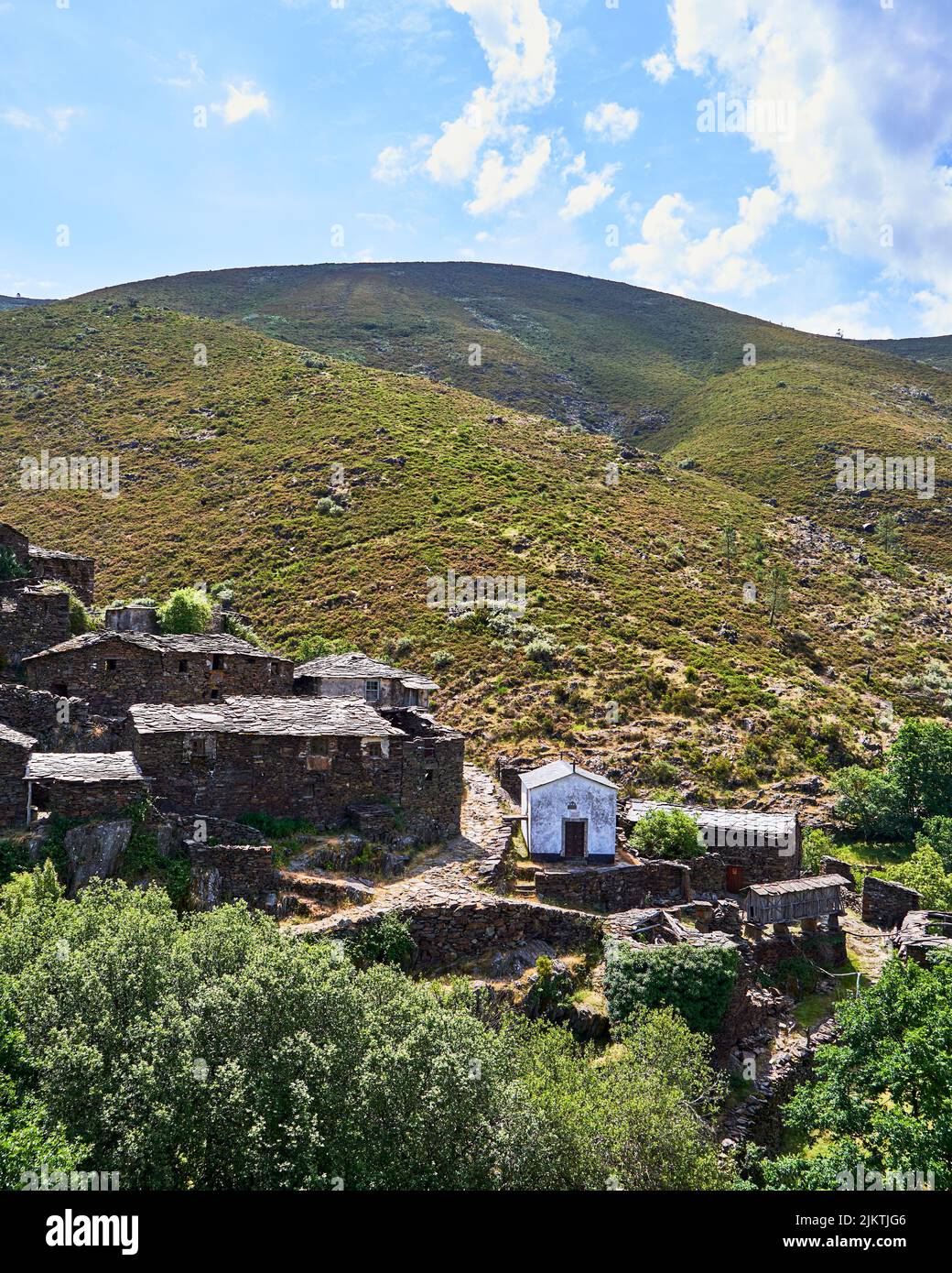 An old church in a village surrounded by mountains in countryside ...
