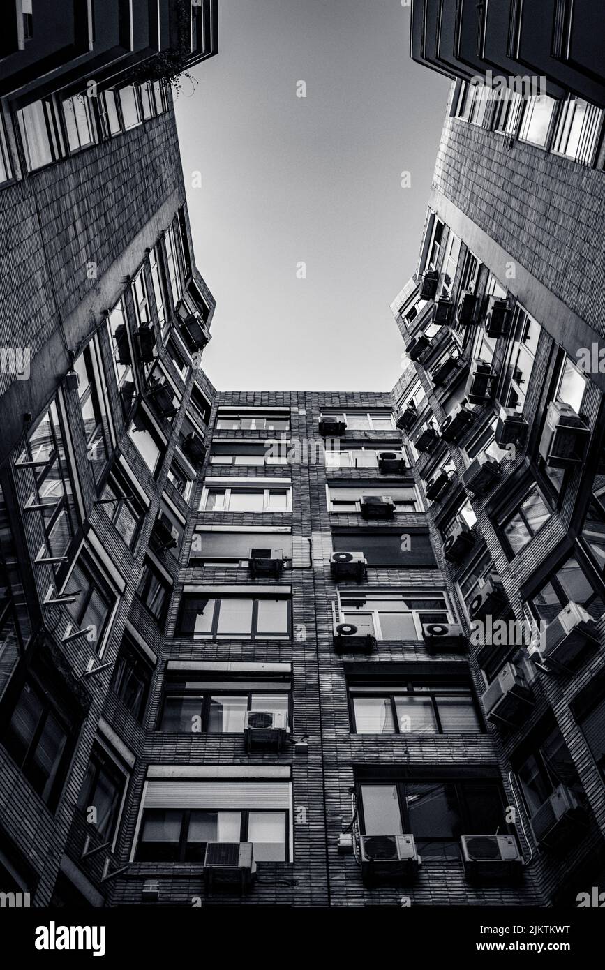 A low angle shot of a old stone building from courtyard in black and ...