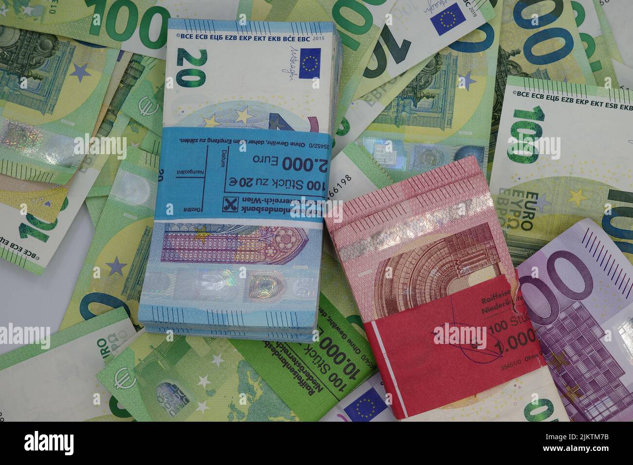 A closeup of stacks of 10, 20, and 100 Euro banknotes on top of a pile ...