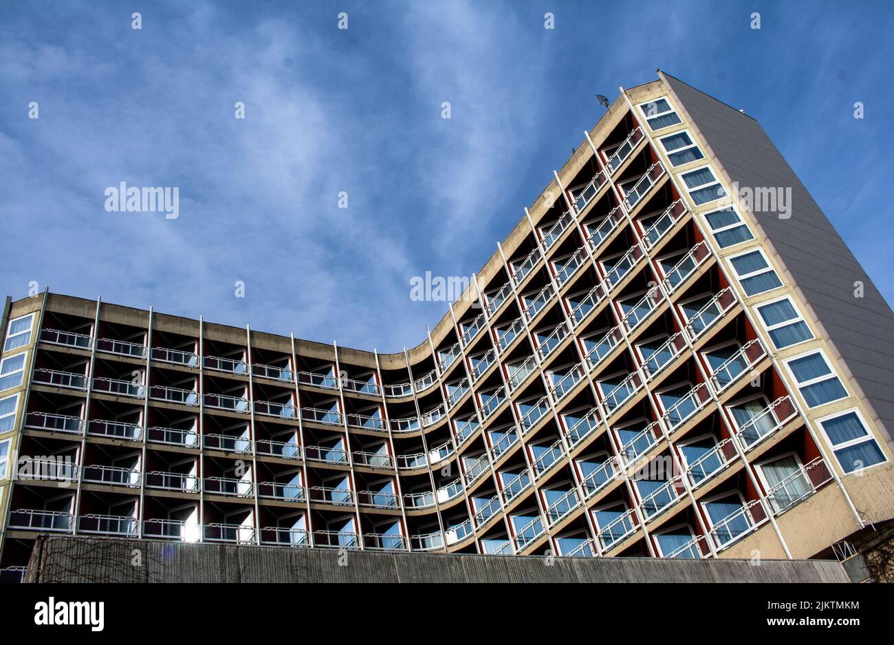 A low-angle shot of a curved modern residential building or a hotel ...