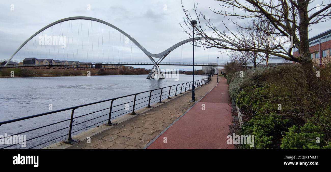 A scenic view of a modern bridge on a river flowing against its bank ...