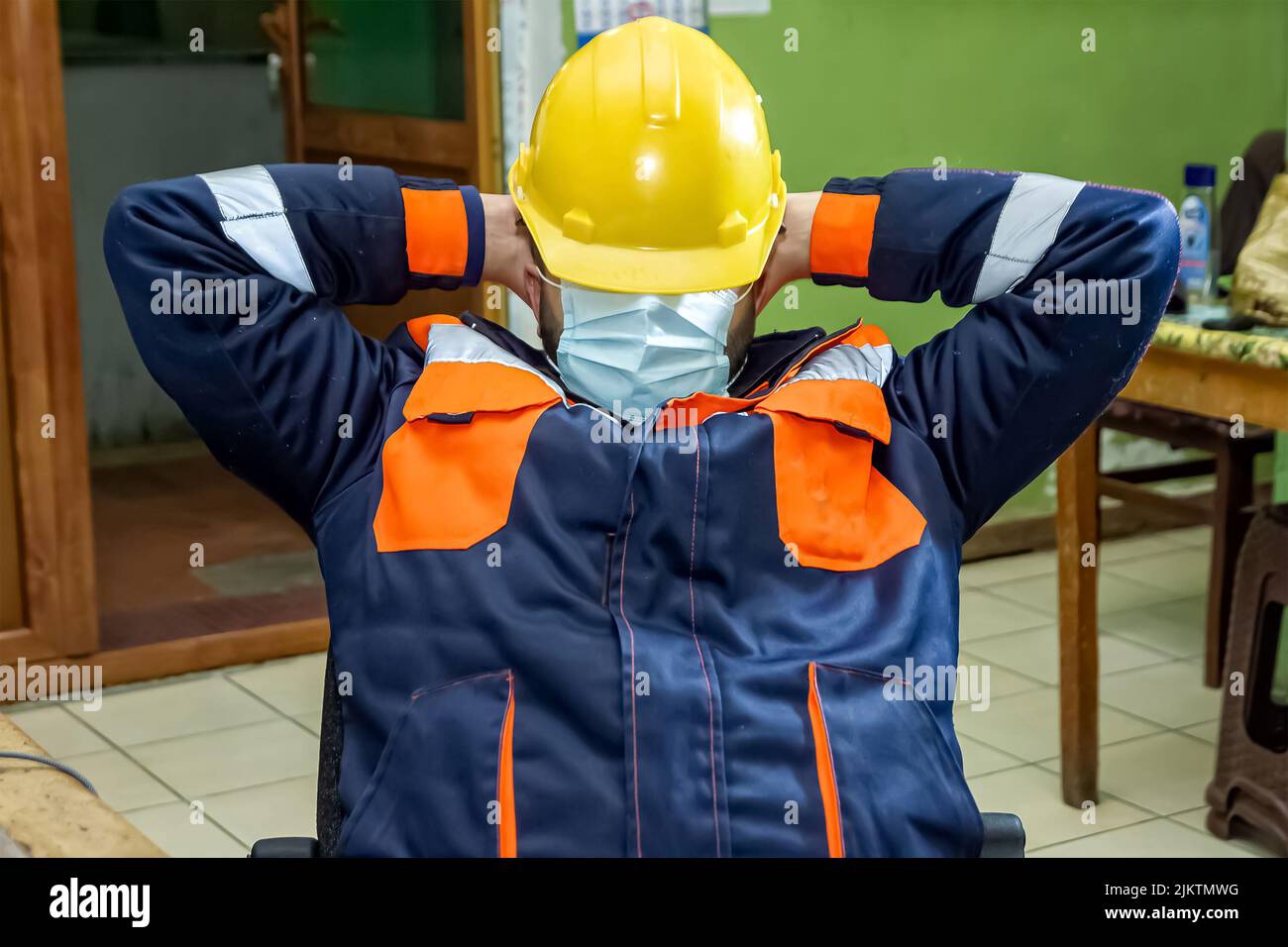 A beautiful shot of a constriction worker sitting with a helmet on his ...