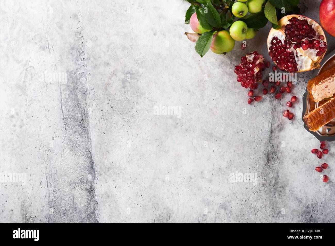 Rosh Hashanah. Honey jar, honeycomb, apple and pomegranate on gray old ...