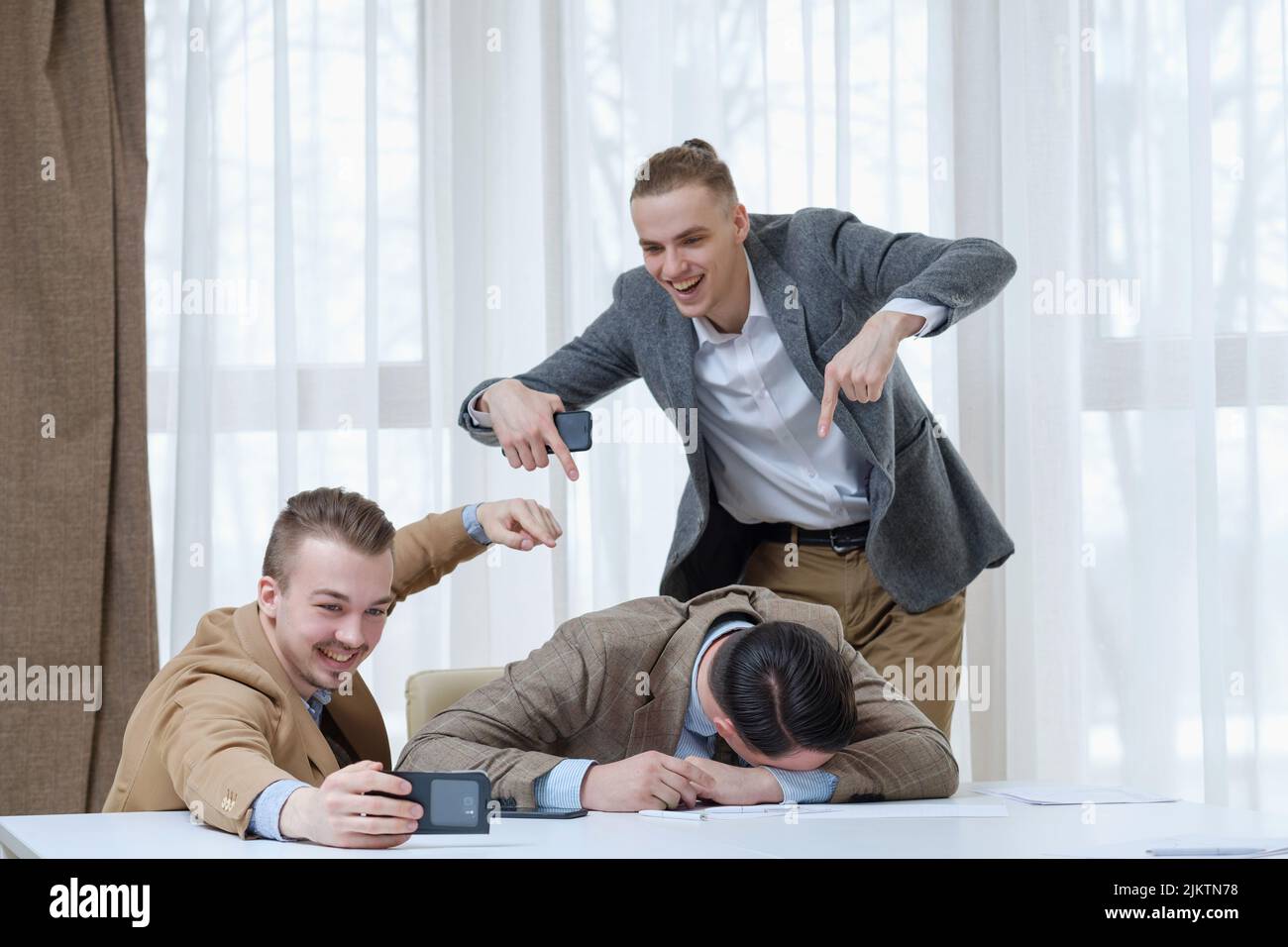 overworking stress laugh tired coworker mocking Stock Photo - Alamy